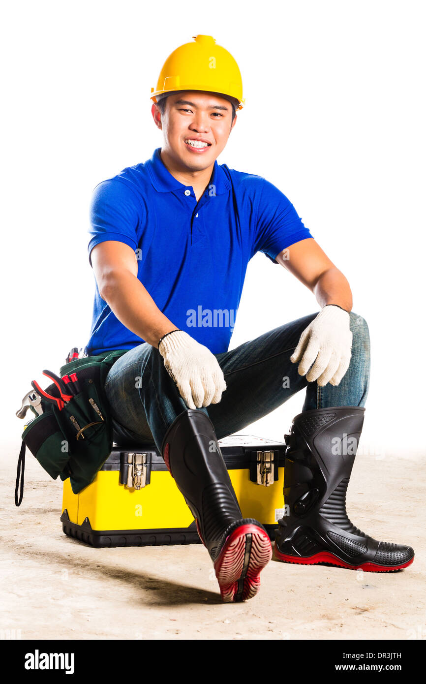 Indonesian Asian builder or construction worker with helmet and tool ...