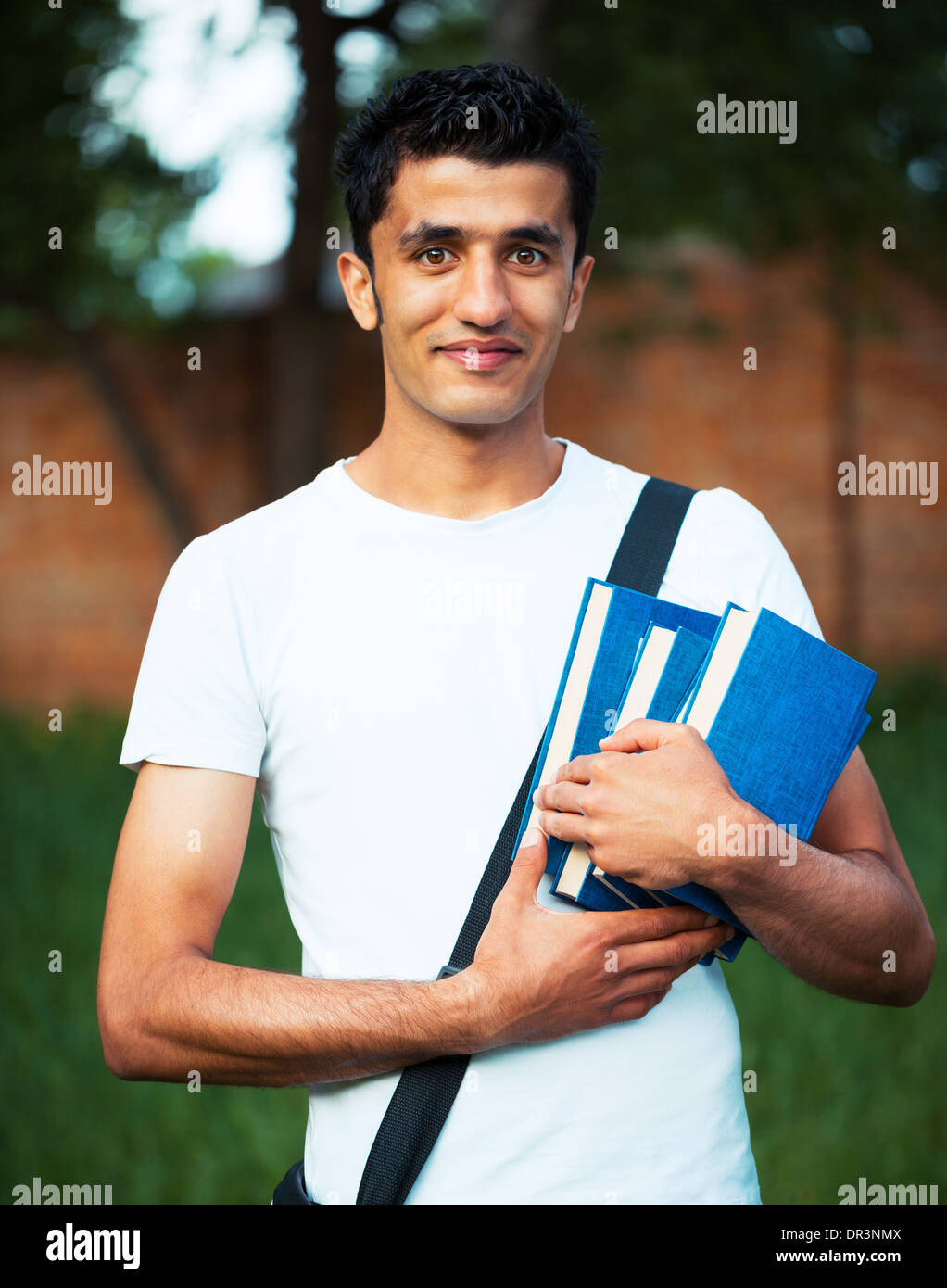 Arab male student with books outdoors looking very happy Stock Photo ...