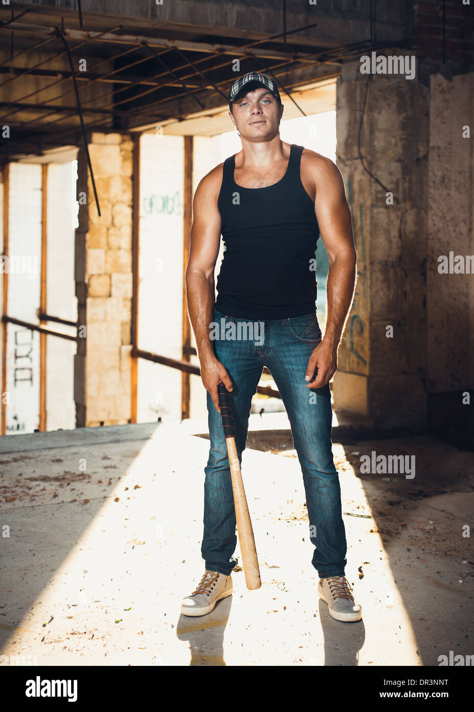Muscular man with baseball bat on the ruins Stock Photo - Alamy