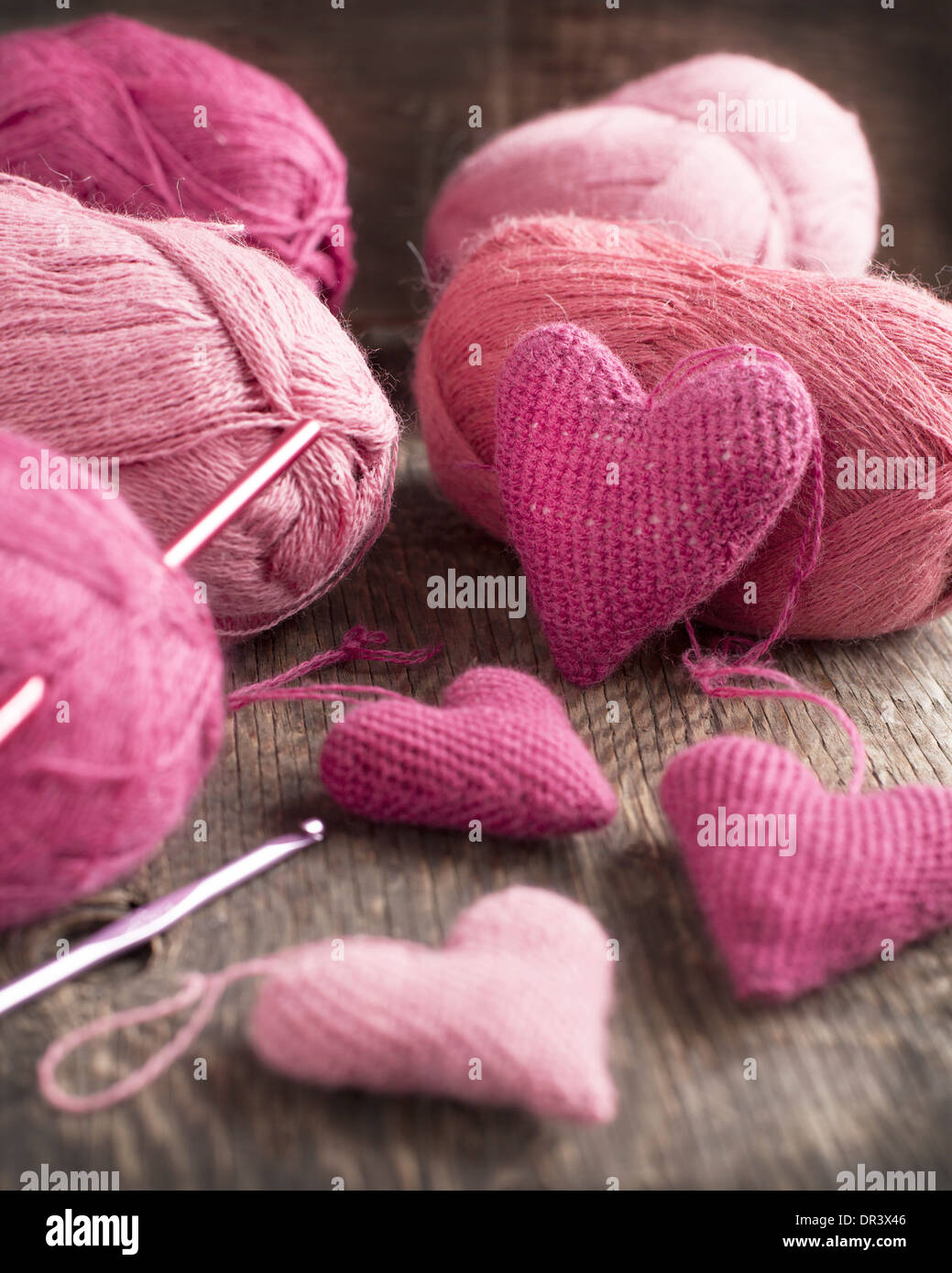 Crochet pink hearts and yarn on wooden background Stock Photo - Alamy
