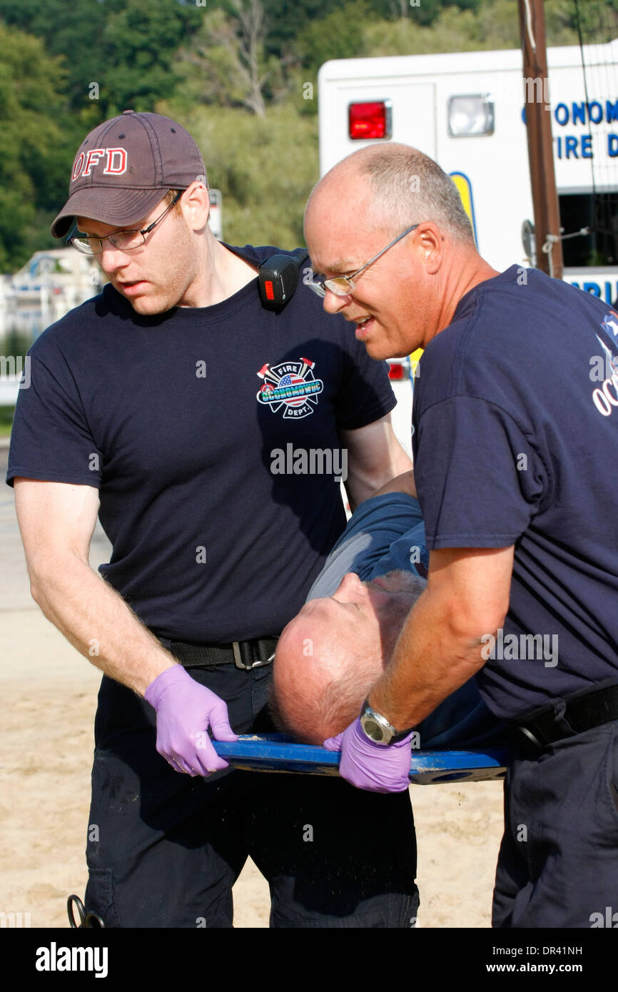 Two EMTs carrying a victim on a backboard off a beach Stock Photo - Alamy