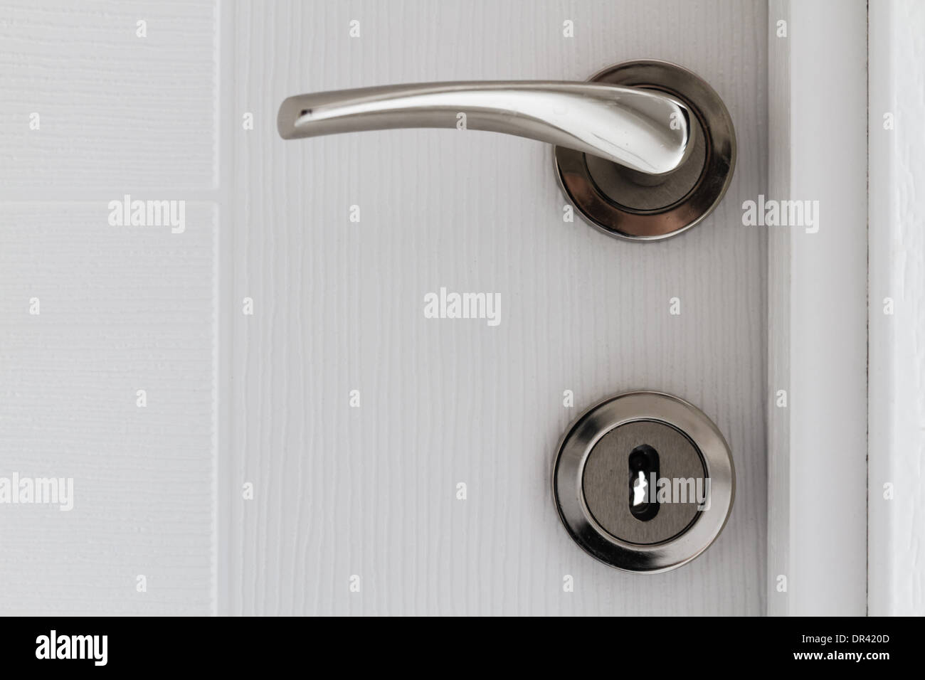 View of a door handle of a closed white door Stock Photo - Alamy