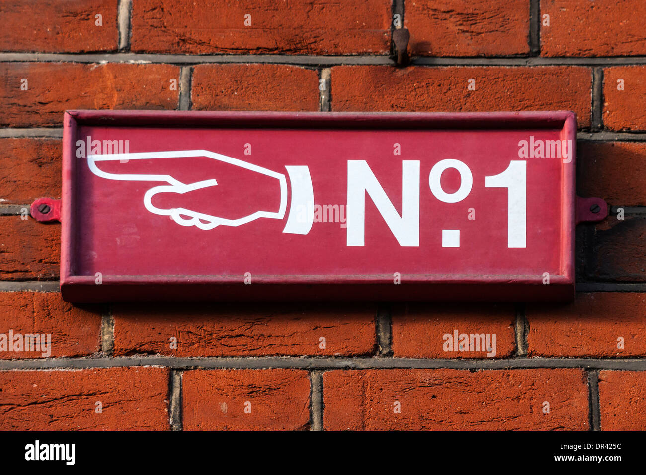 Number One Wallmounted Sign with pointing hand Stock Photo - Alamy