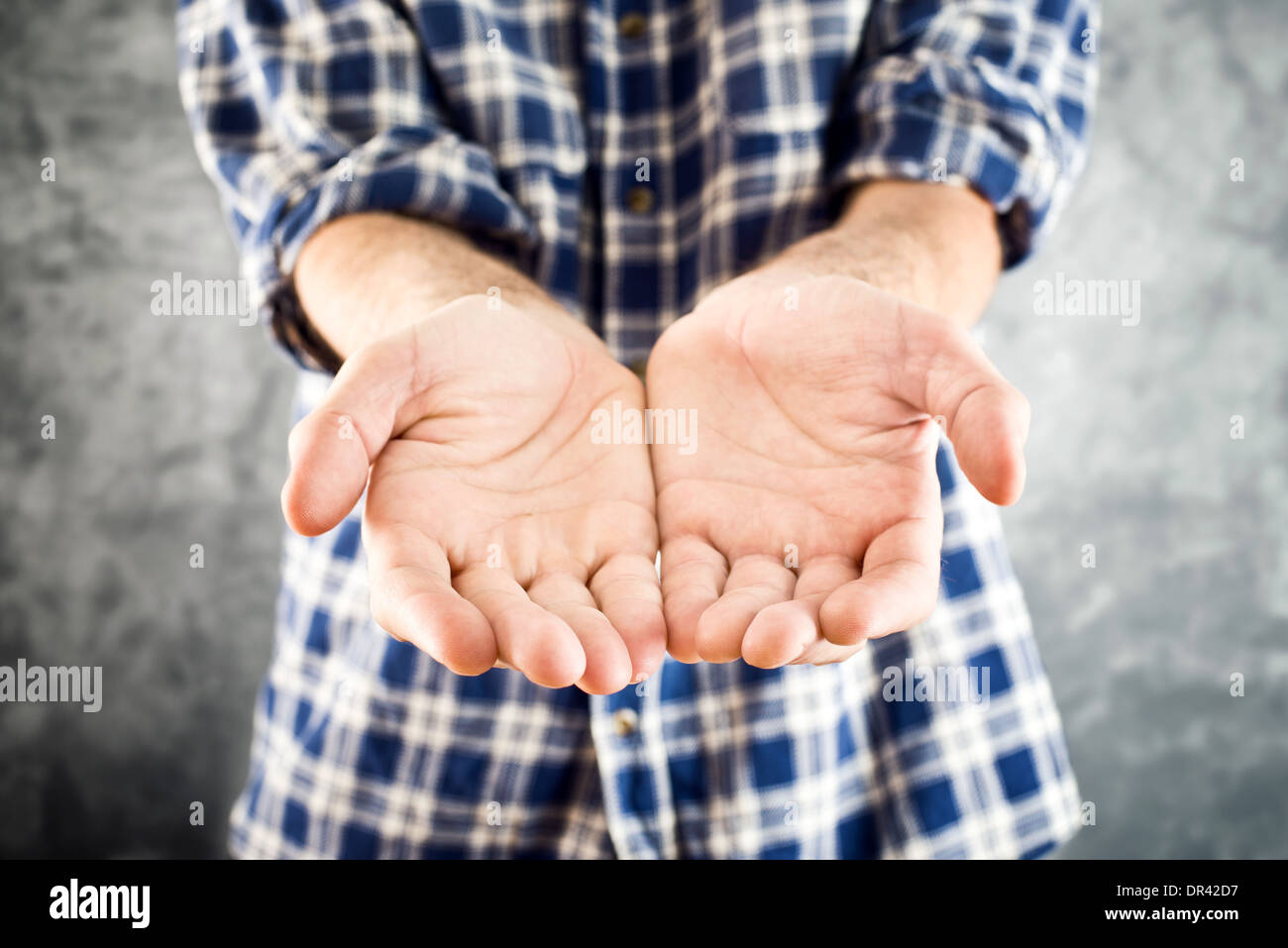 Cupped hands of a man hopefully held up. Cupped hands asking for help ...
