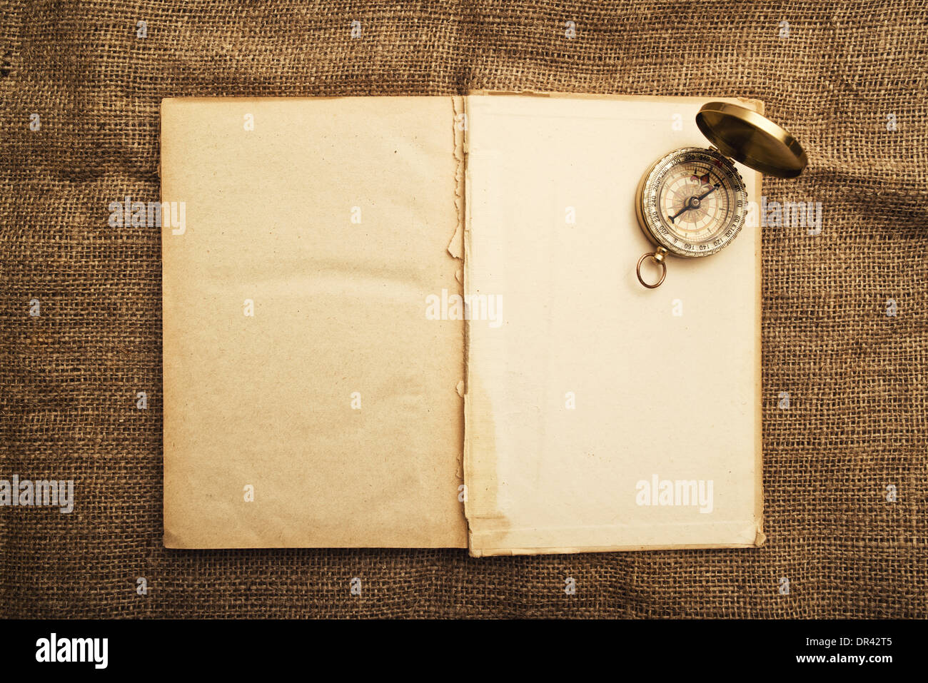 Vintage open book with old navigation compass Stock Photo - Alamy