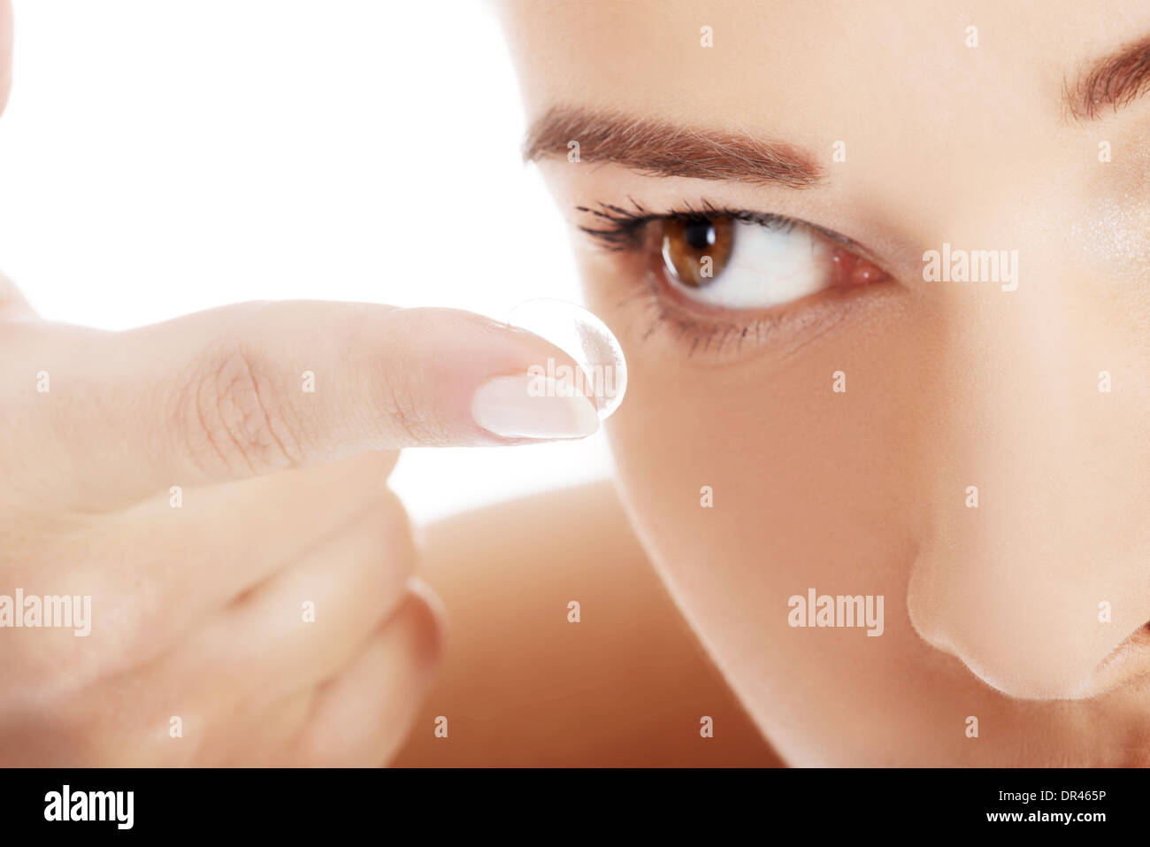 Close up on woman putting lens into eye. Over white background Stock ...