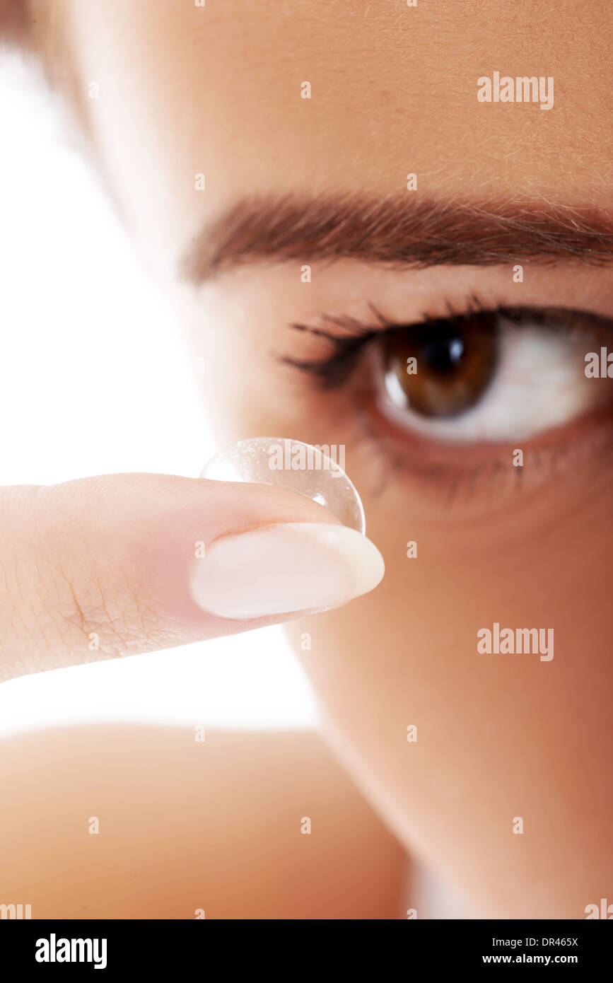 Close up on woman putting lens into eye. Over white background Stock ...