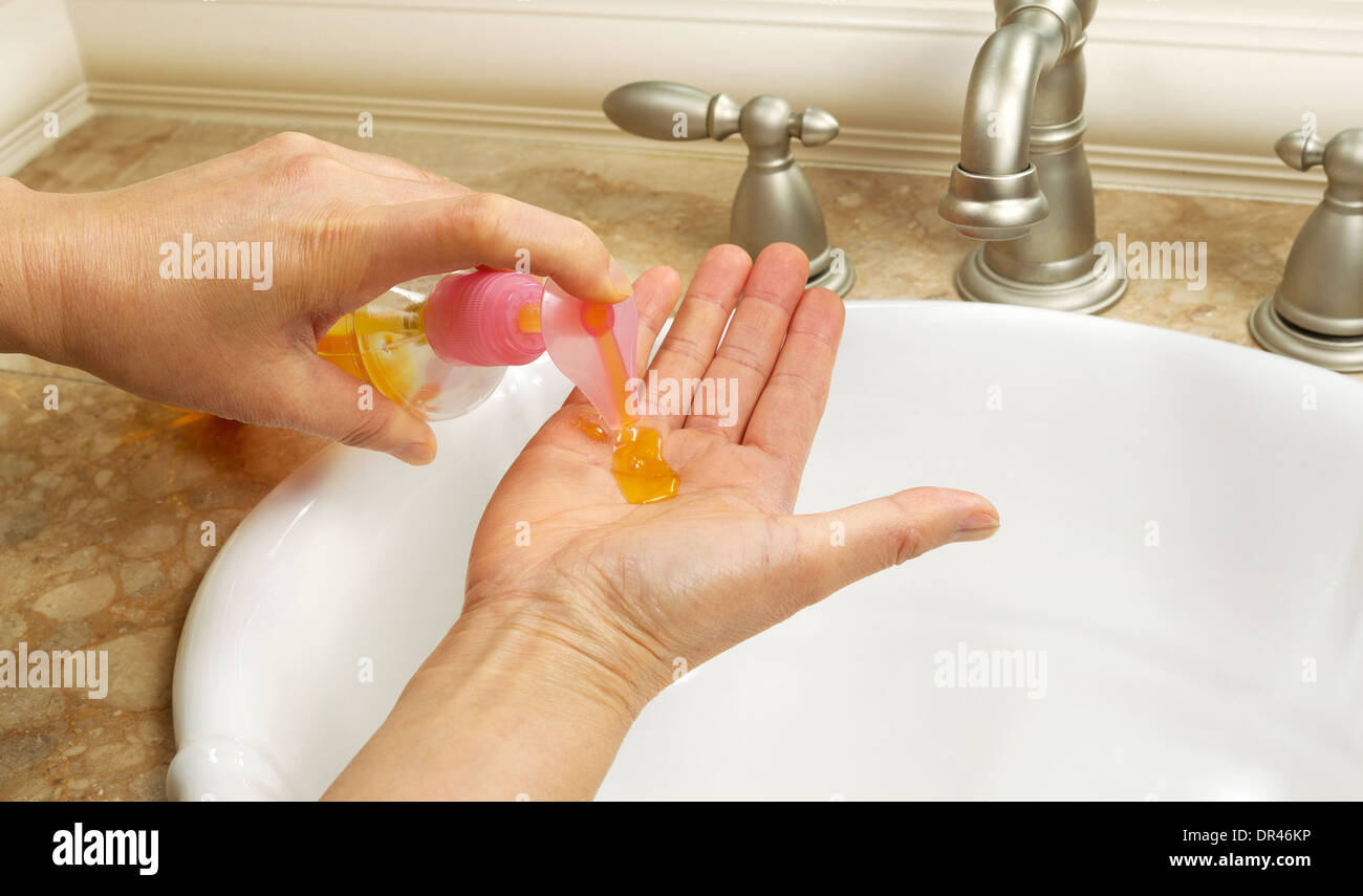 Horizontal photo of female hands putting liquid soap in palm of hand ...