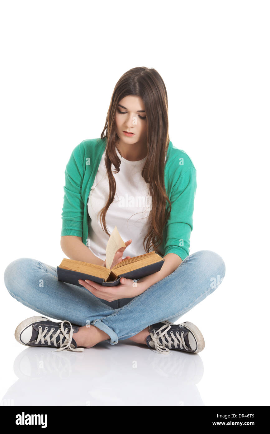 Young beautiful student sitting with book, reading, learning. Isolated ...