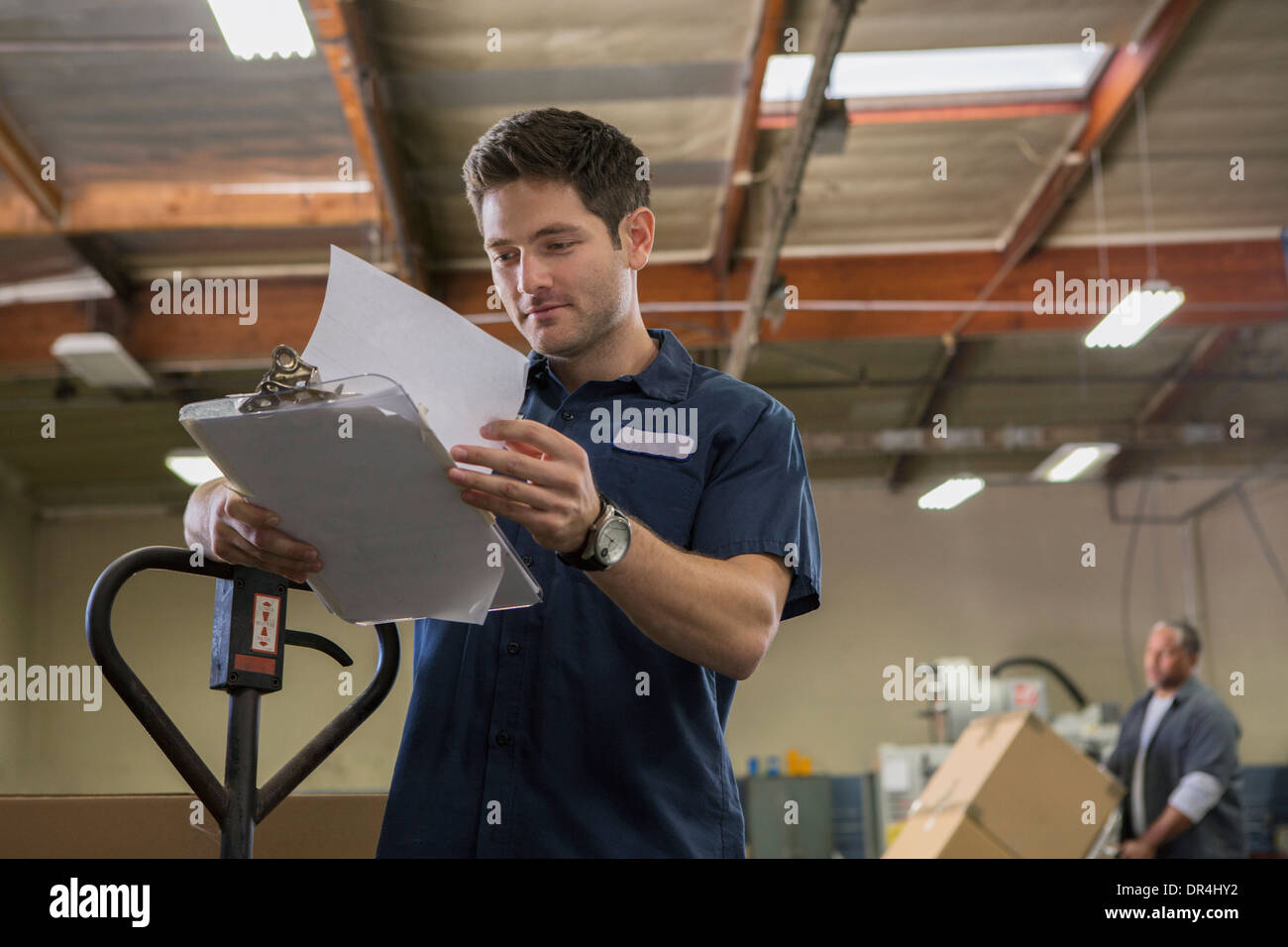 Worker reading clipboard in warehouse Stock Photo - Alamy