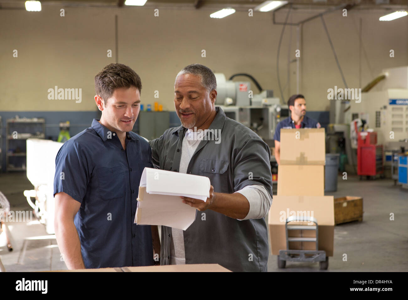 Workers talking in warehouse Stock Photo - Alamy