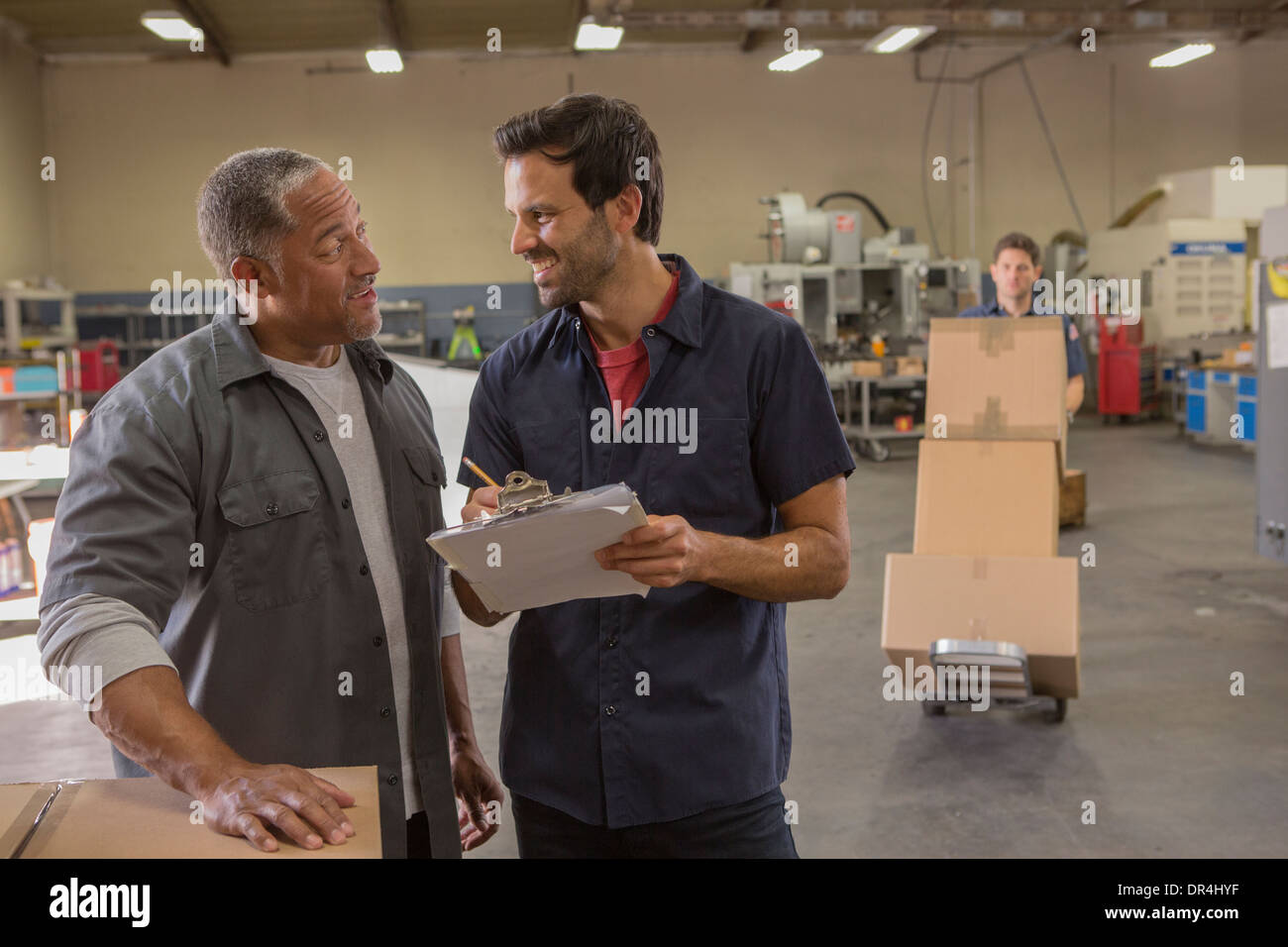Workers talking in warehouse Stock Photo - Alamy