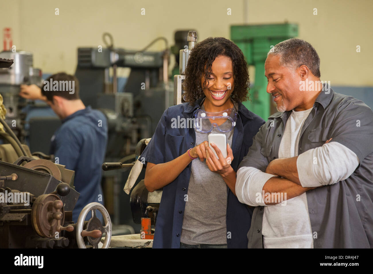 Workers using cell phone in warehouse Stock Photo - Alamy