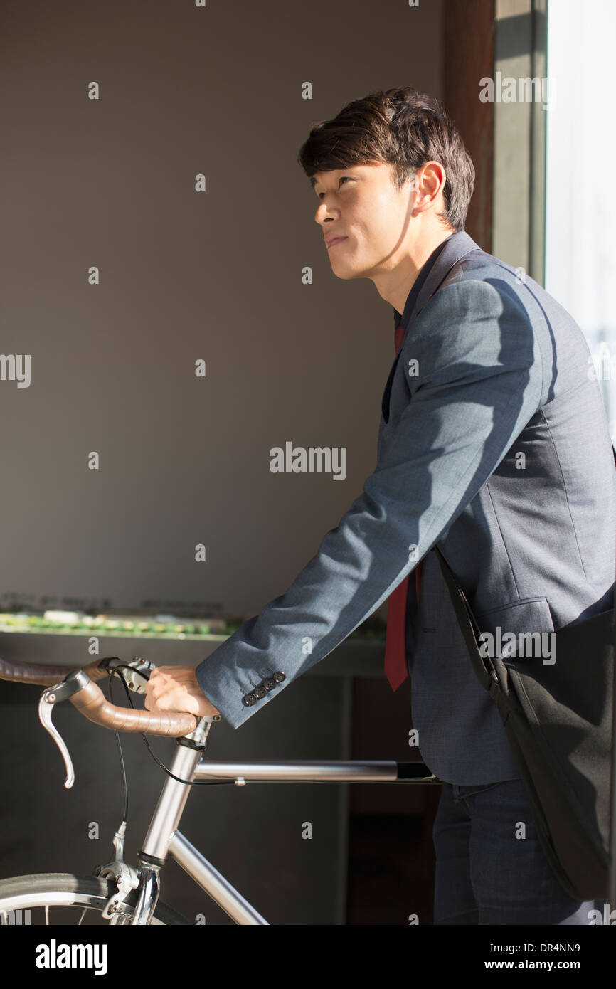 Korean businessman wheeling bicycle in office Stock Photo - Alamy