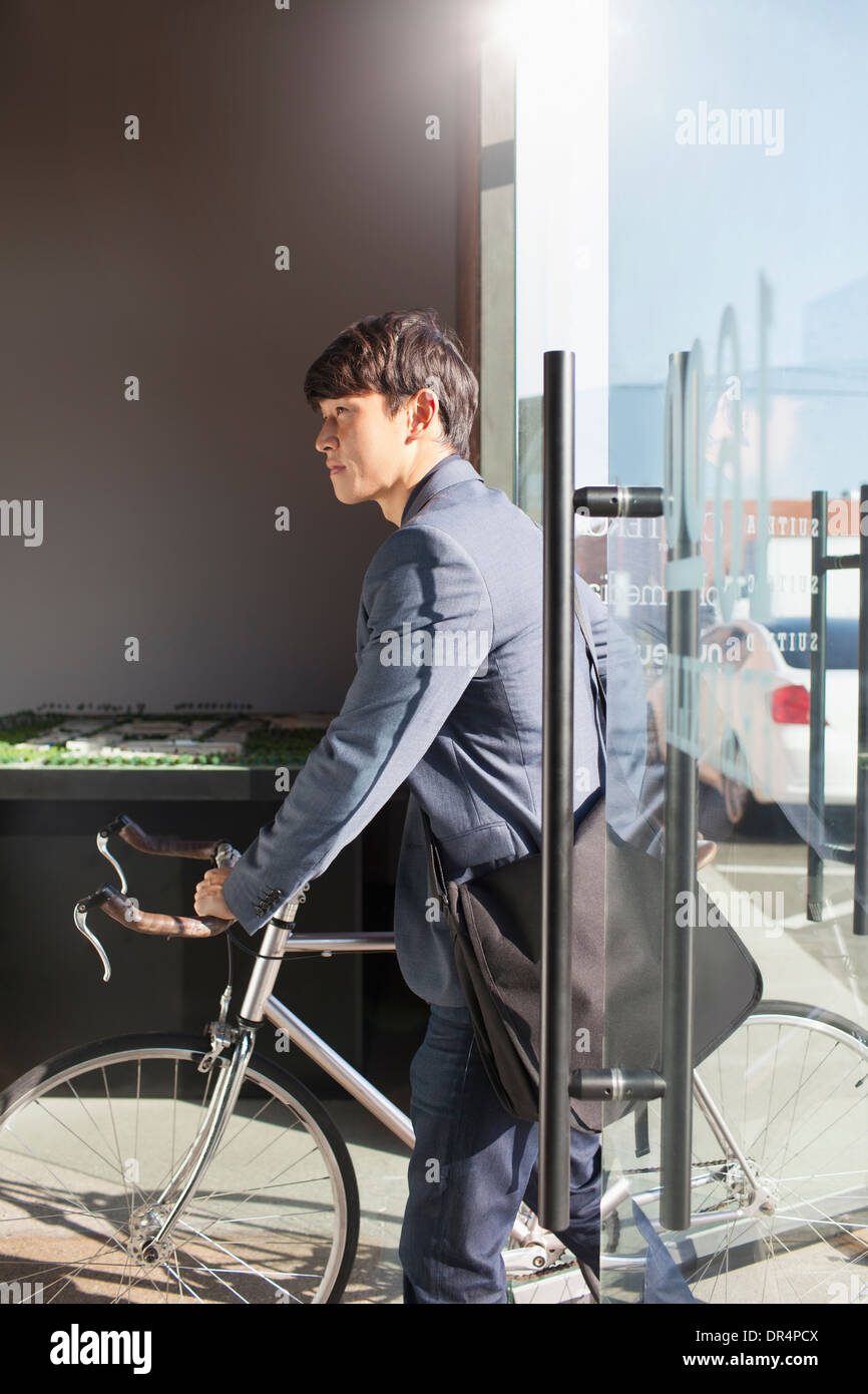 Korean businessman wheeling bicycle in office Stock Photo - Alamy