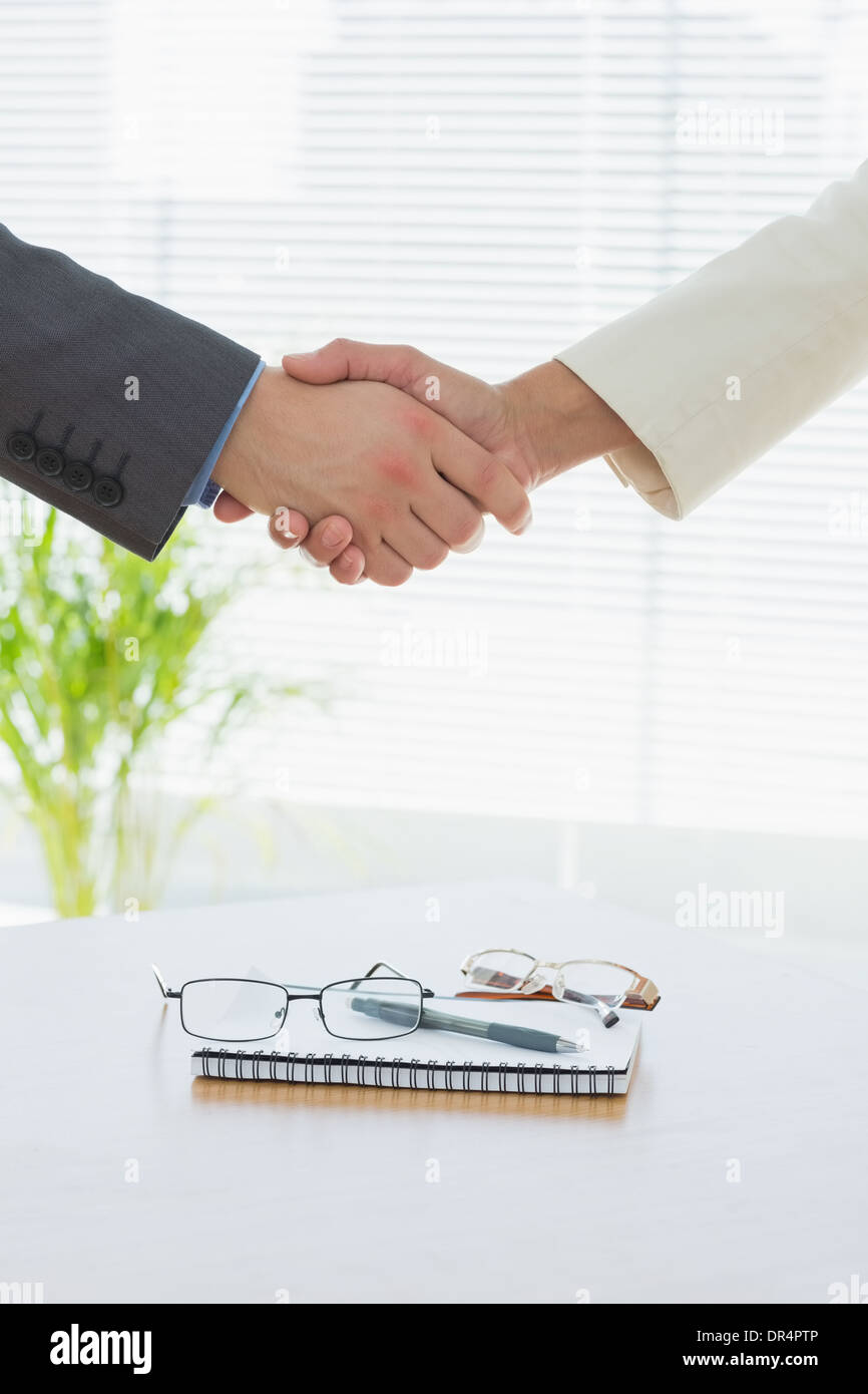 Closeup of shaking hands over eye glasses and diary Stock Photo - Alamy