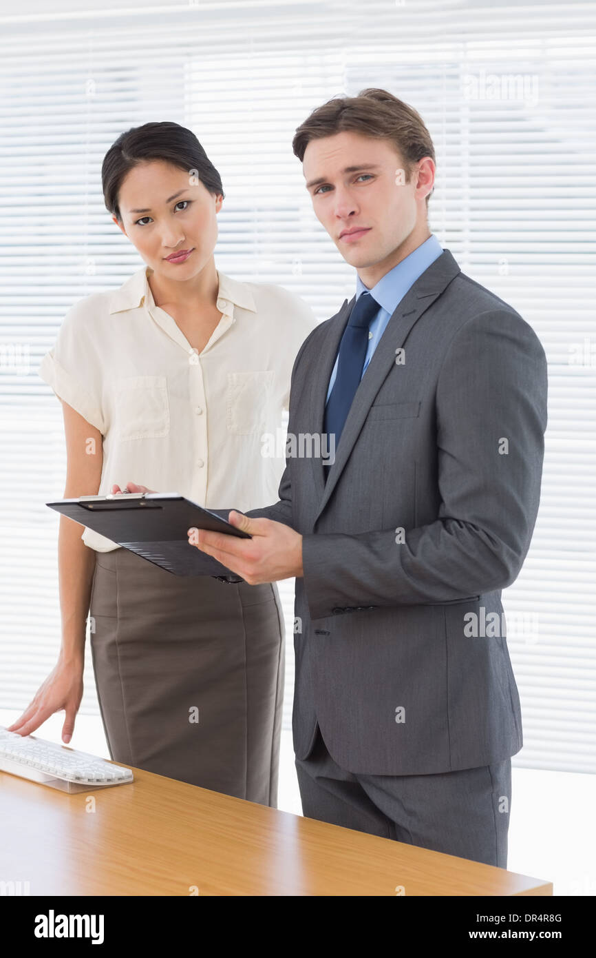 Confident business colleagues with clipboard at office Stock Photo - Alamy