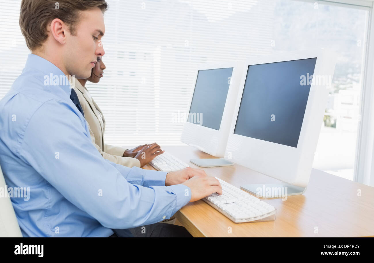 Cusiness colleagues using computers at desk Stock Photo - Alamy