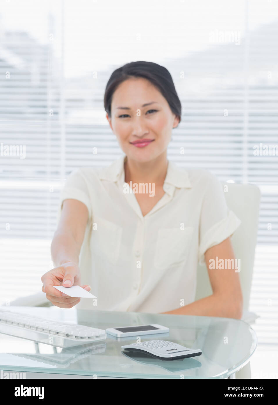 Woman handing over her business card at desk Stock Photo - Alamy