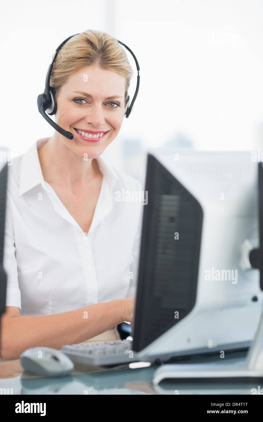 Female executive with headset using computer at desk Stock Photo - Alamy