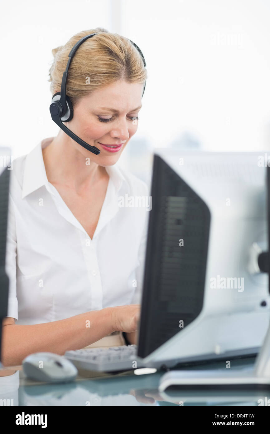 Female executive with headset using computer at desk Stock Photo - Alamy