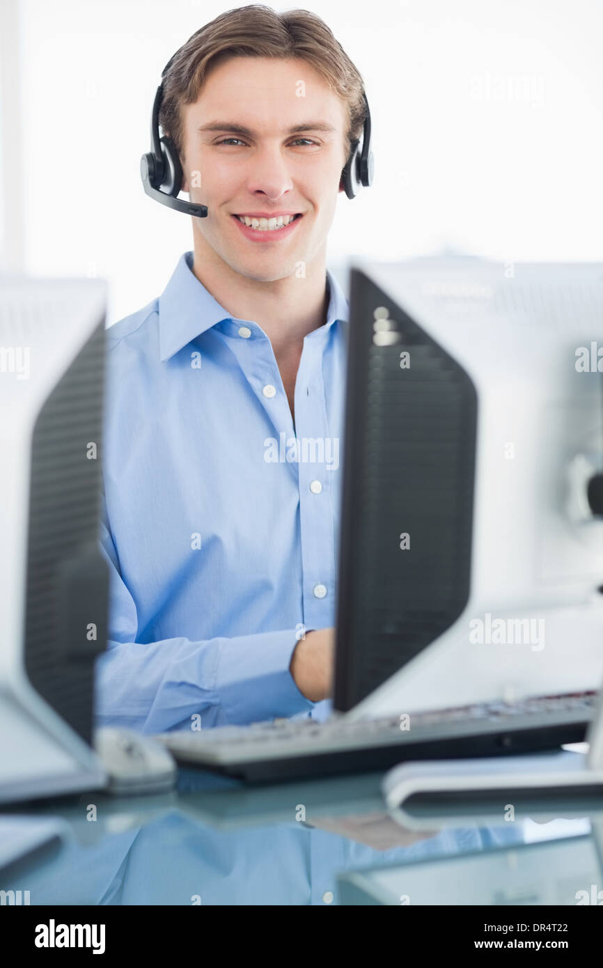 Male executive with headset using computer at desk Stock Photo - Alamy
