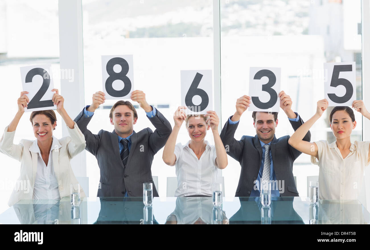 Group of panel judges holding score signs Stock Photo - Alamy
