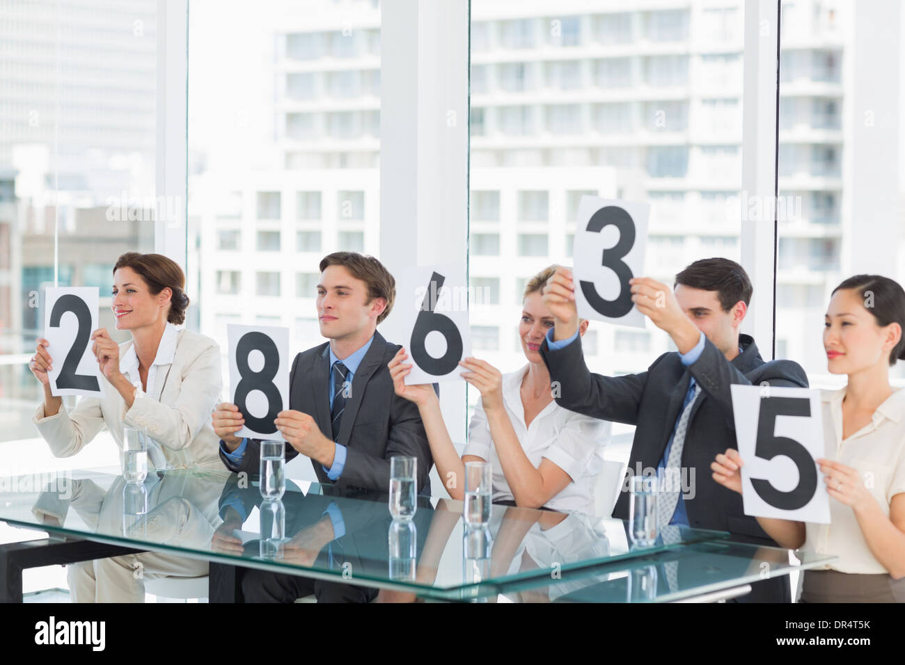 Group of panel judges holding score signs Stock Photo - Alamy