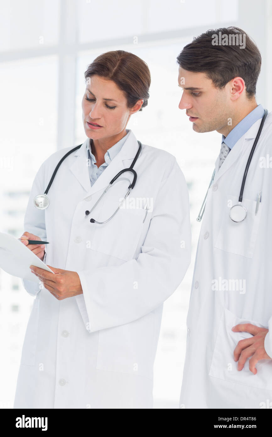 Doctors looking at report in hospital Stock Photo - Alamy