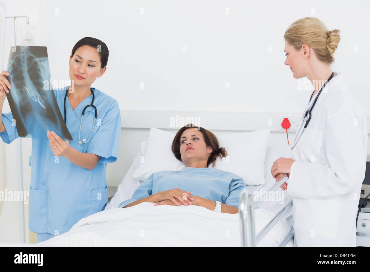 Doctors examining x-ray with patient in hospital Stock Photo - Alamy