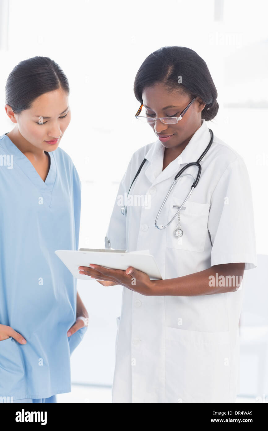 Female doctor and surgeon looking at report Stock Photo - Alamy