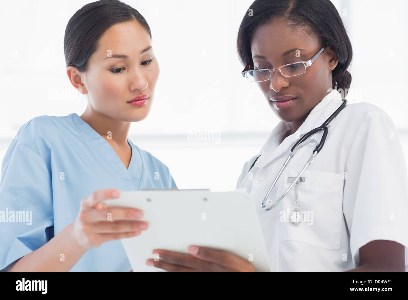 Female doctor and surgeon looking at report Stock Photo - Alamy