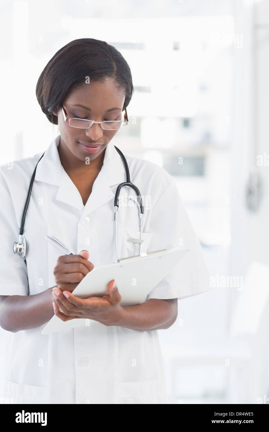 Female doctor writing report Stock Photo - Alamy