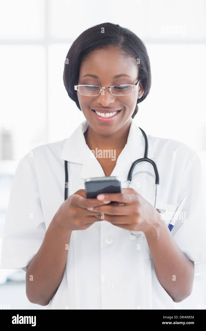 Smiling female doctor holding a mobile phone Stock Photo - Alamy