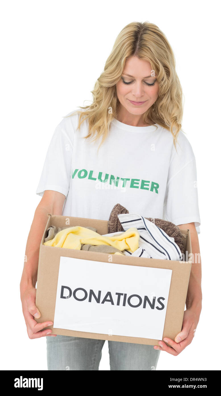 Smiling young woman carrying clothes donation Stock Photo - Alamy