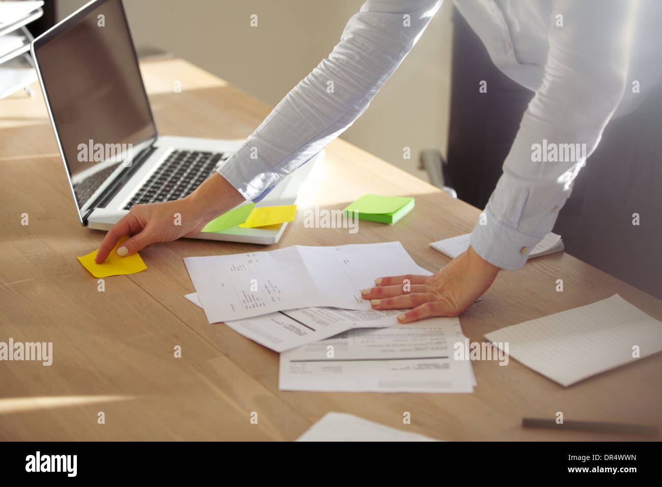 Closeup of businesswoman checking notes on post it. Female executive in ...