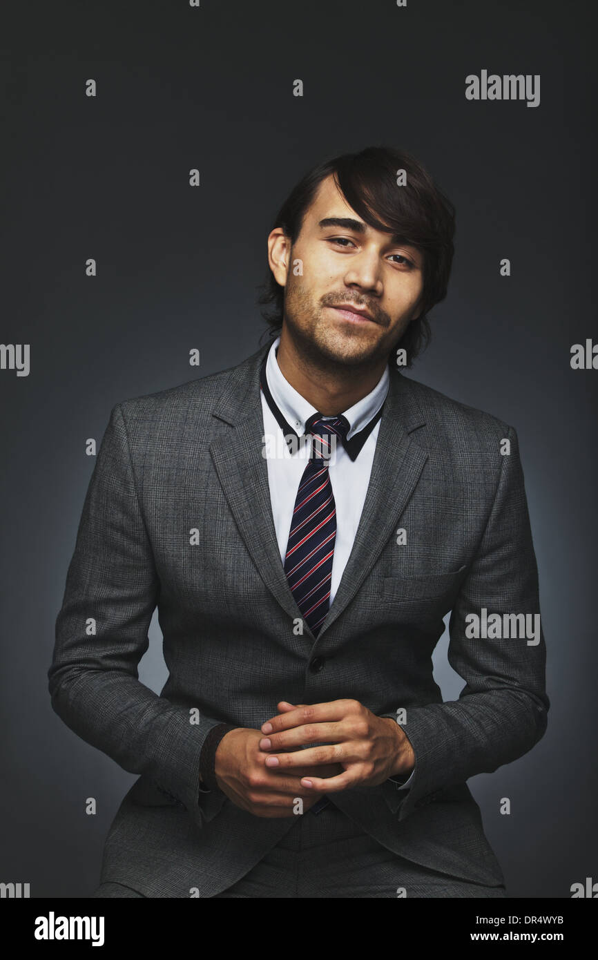 Portrait of good looking young man wearing business suit posing against ...