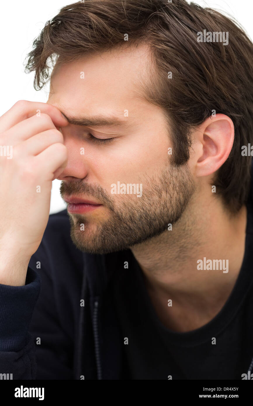 Close-up of a stressed handsome young man with eyes closed over white ...
