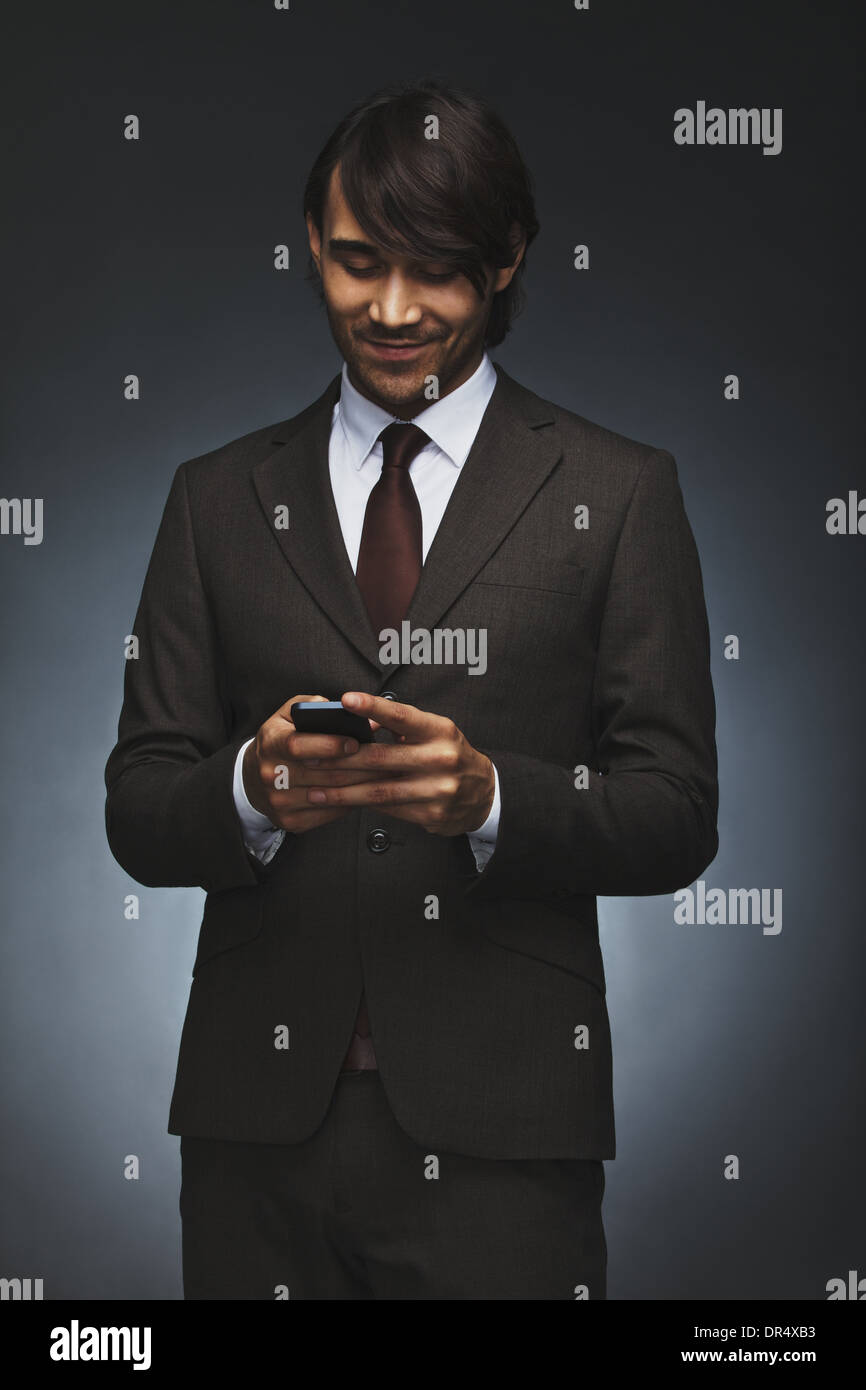 Happy young executive texting on his smart phone. Handsome male ...