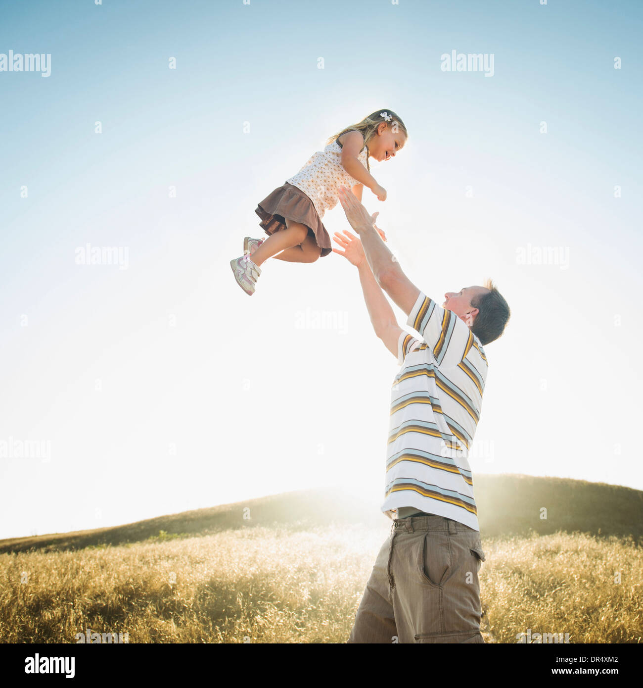 Caucasian father lifting daughter overhead in rural field Stock Photo ...