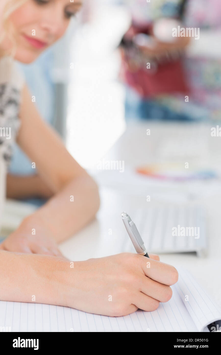 Side view of a casual young woman writing notes Stock Photo - Alamy