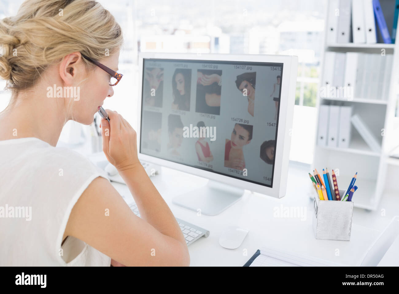 Rear view of a female photo editor working on computer Stock Photo - Alamy