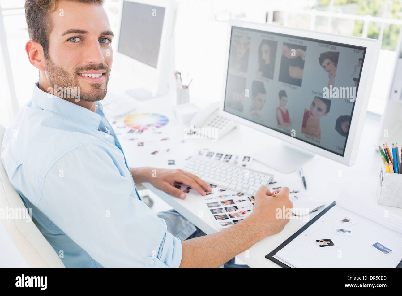 Male photo editor working on computer in a bright office Stock Photo ...