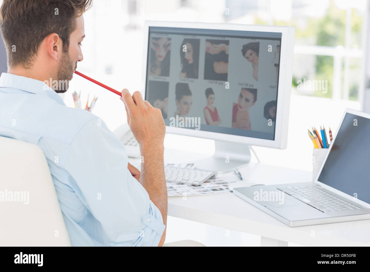 Male photo editor working on computer in office Stock Photo - Alamy