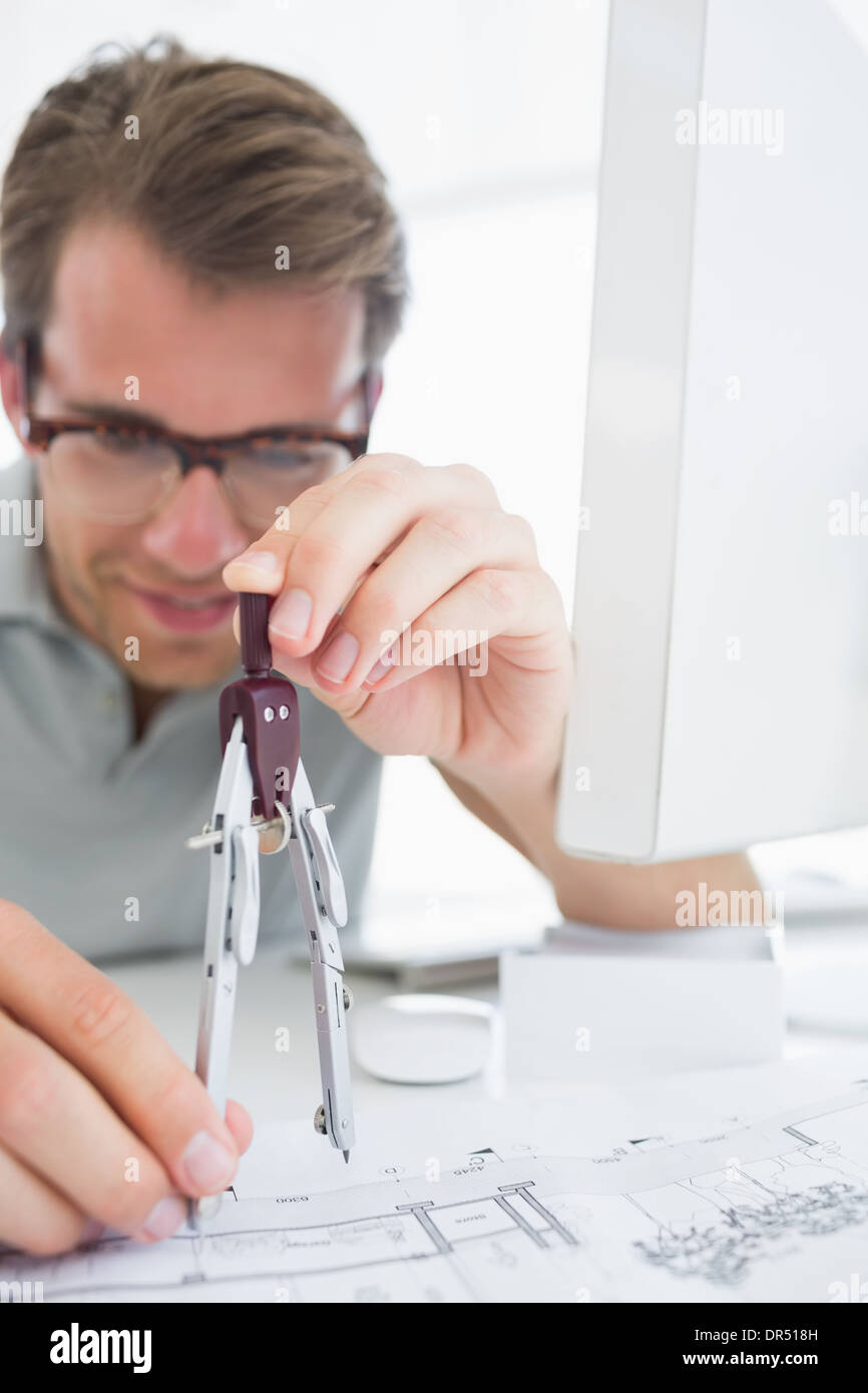 Concentrated man using compass on design Stock Photo - Alamy