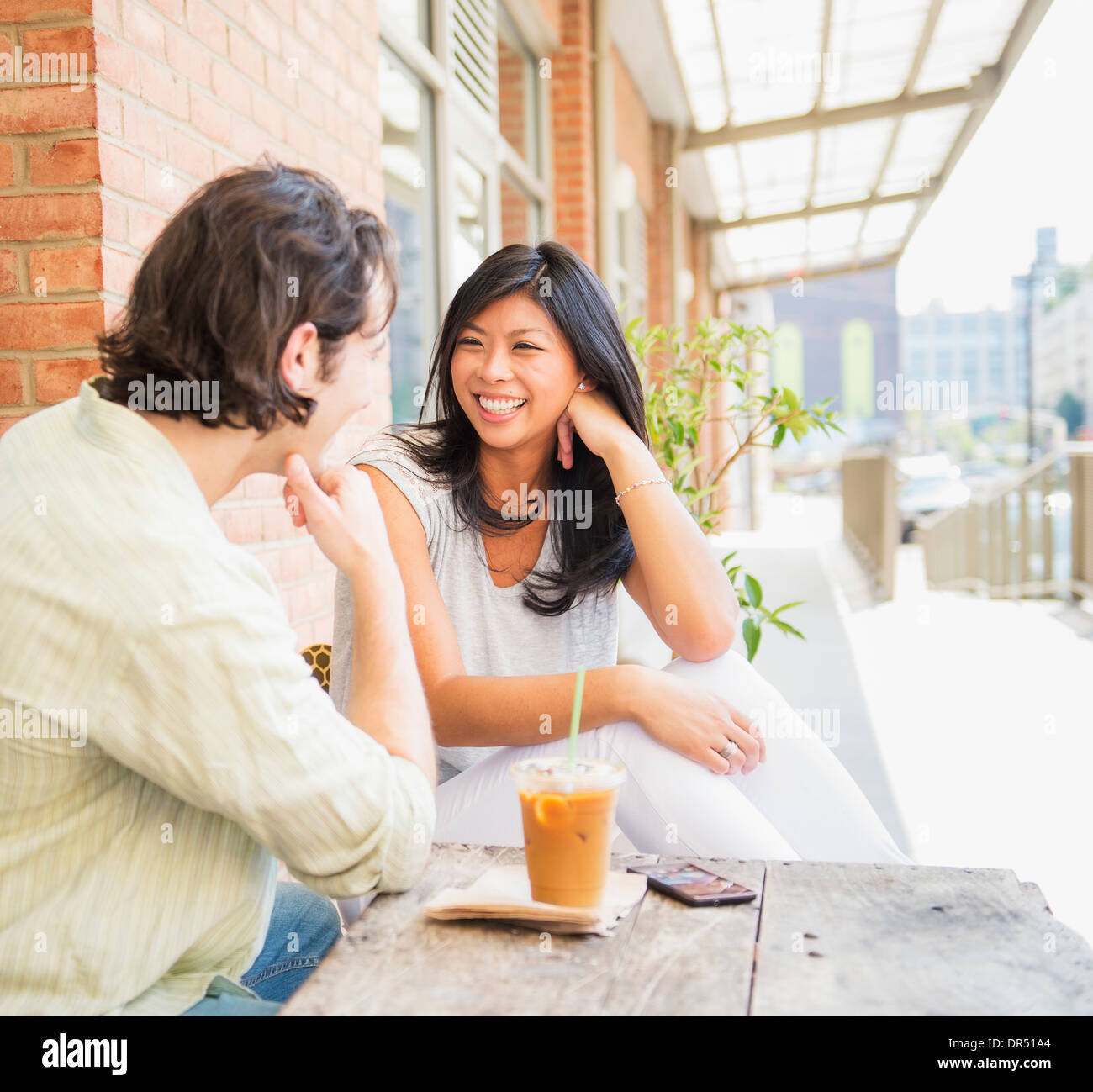 Couple enjoying iced coffee at sidewalk cafe Stock Photo - Alamy