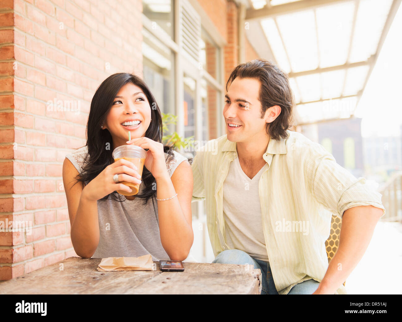 Couple enjoying iced coffee at sidewalk cafe Stock Photo - Alamy
