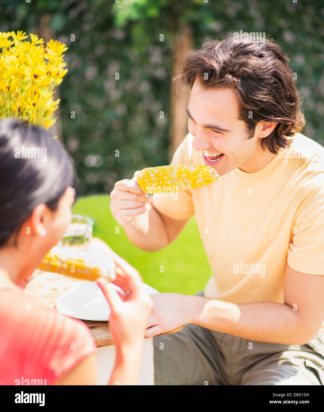 Couple eating corn on the cob outdoors Stock Photo - Alamy