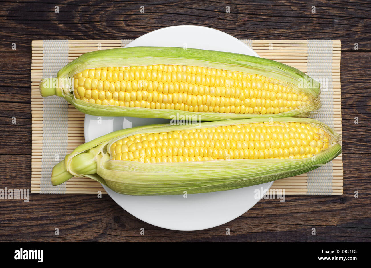 Two corn cob on wooden table. Top view Stock Photo - Alamy