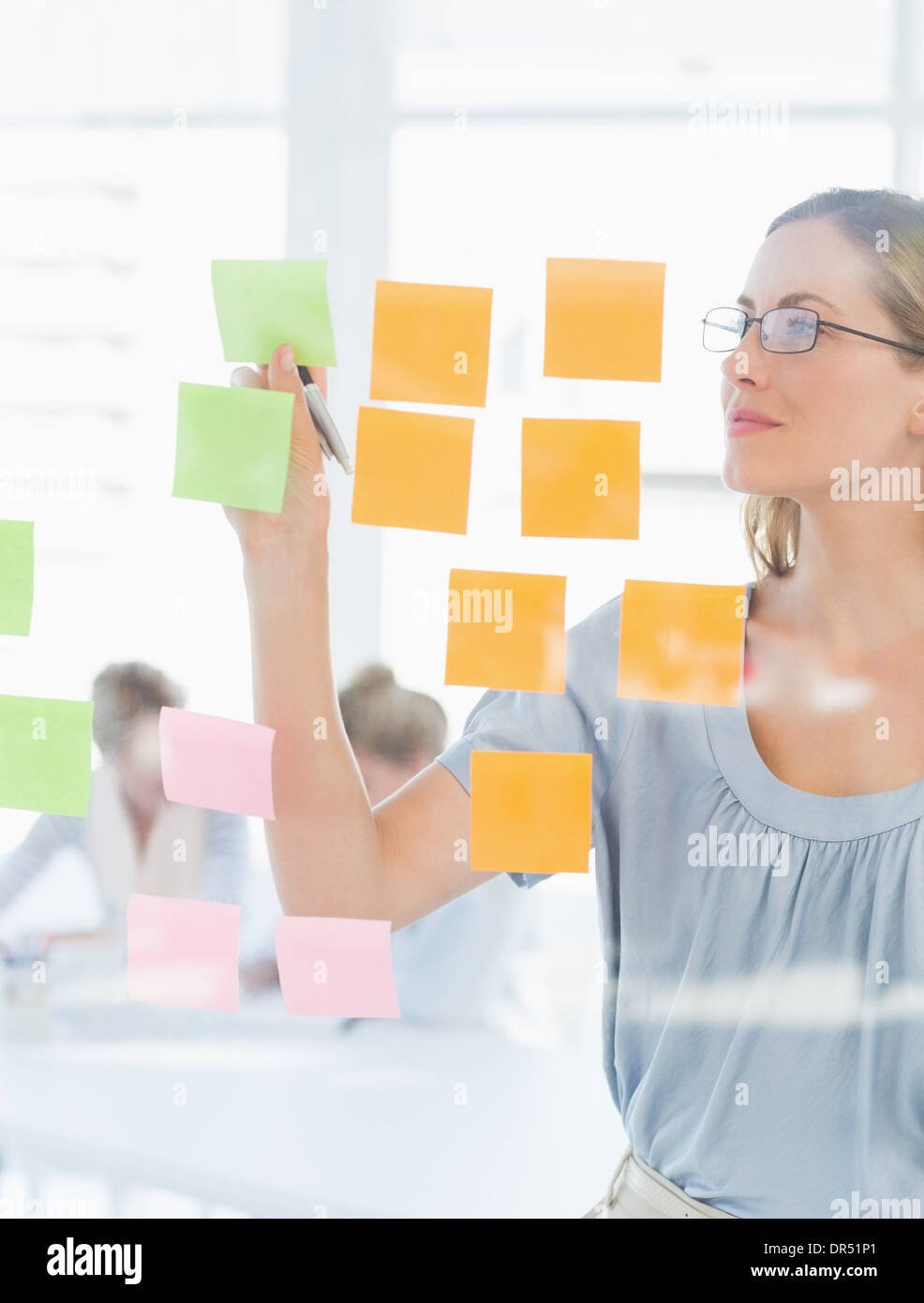 Concentrated artist looking at colorful sticky notes Stock Photo - Alamy